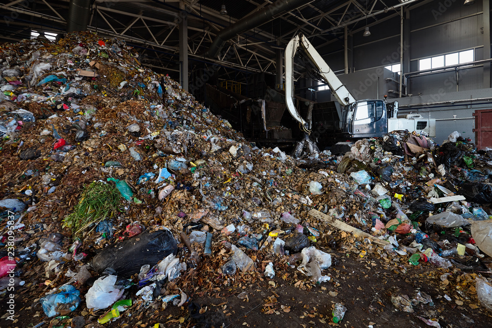 Modern recycling plant process of unloading garbage, manipulator loads ...