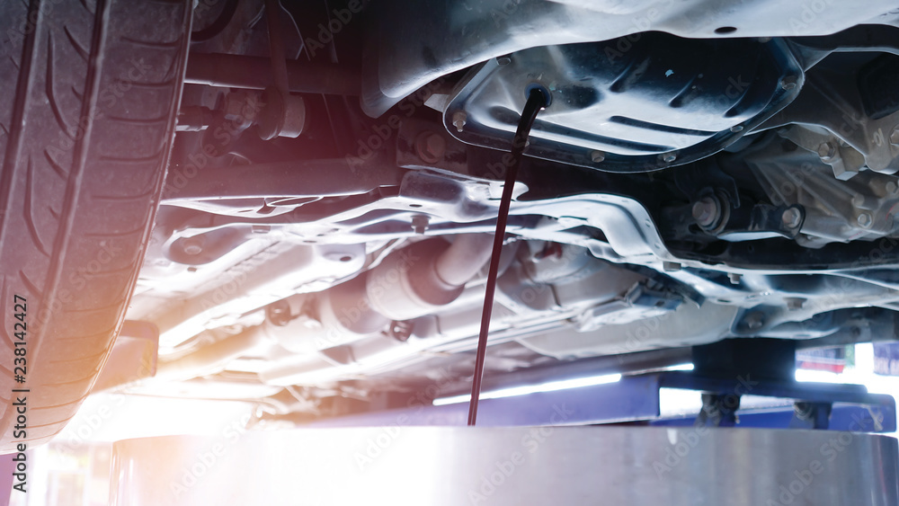 The oil is flowing from the engine under the car while the engine oil ...
