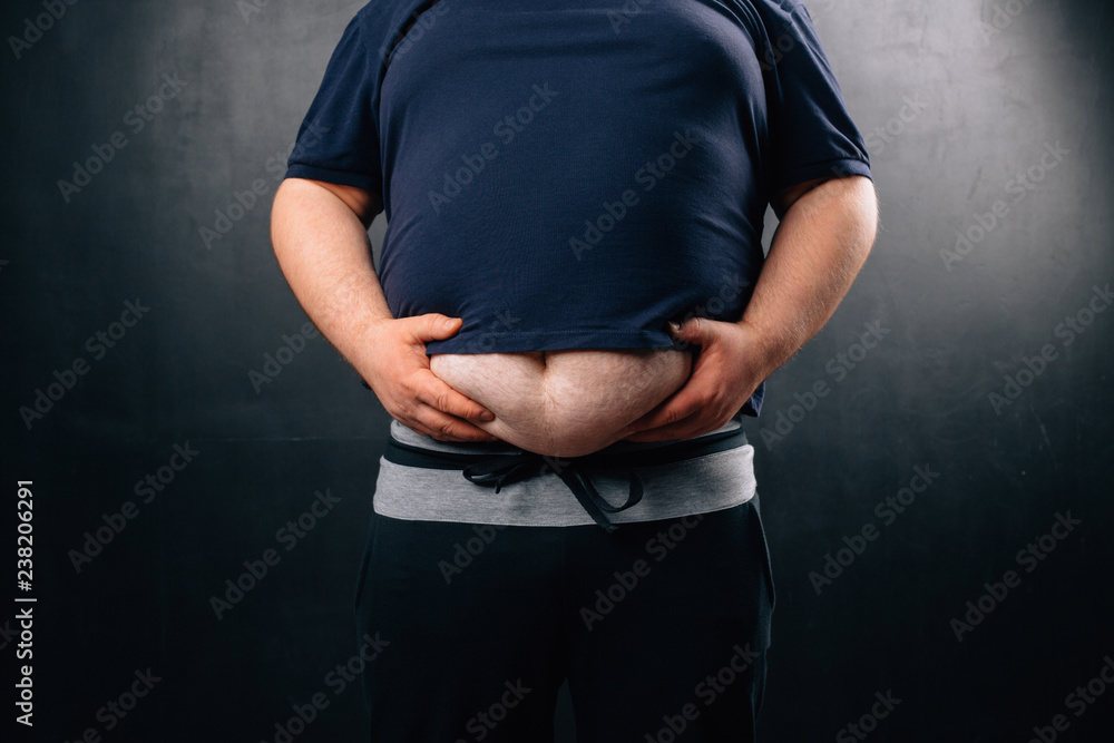 Fat man with a big belly on a dark background. Diet. Stock Photo ...