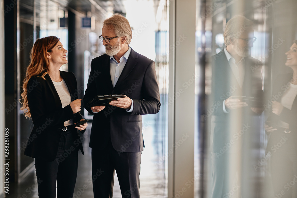 Co-workers discussing an important matter on a empty hallway. Stock ...