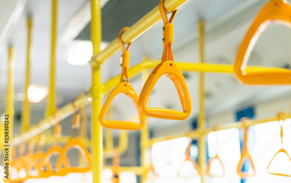 Yellow bus handle on the ceiling for standing passenger, public ...