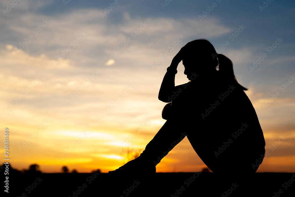 Silhouette of sad and depressed women sitting at walkway of park with ...