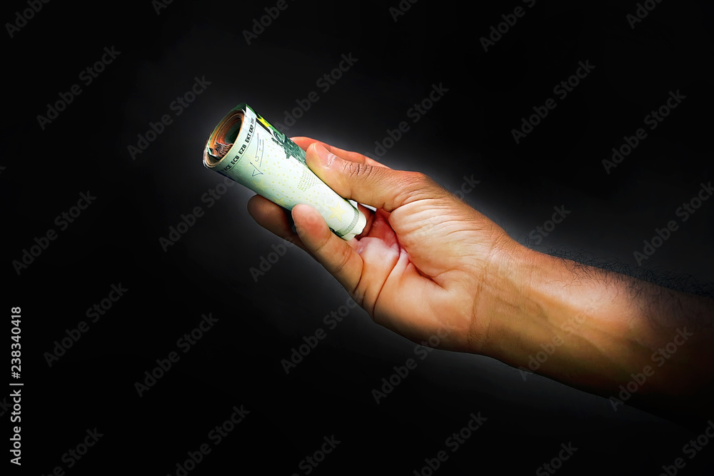 Hand of office worker gives a bribe roll euro banknote to an employee ...