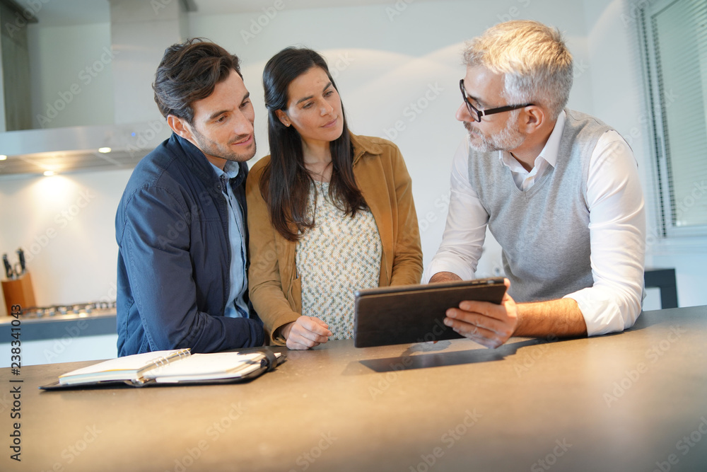 Kitchen salesman going through ideas with potential buyer couple Photos ...