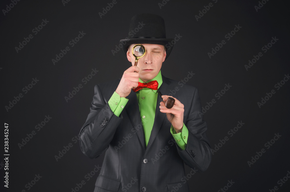 Spy secret agent is looking through a magnifying glass and smokes a ...