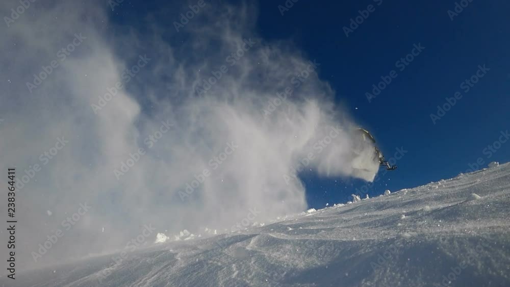 Stockvideon a snowmobile rider jumps up with a trail of snow whirlwinds ...