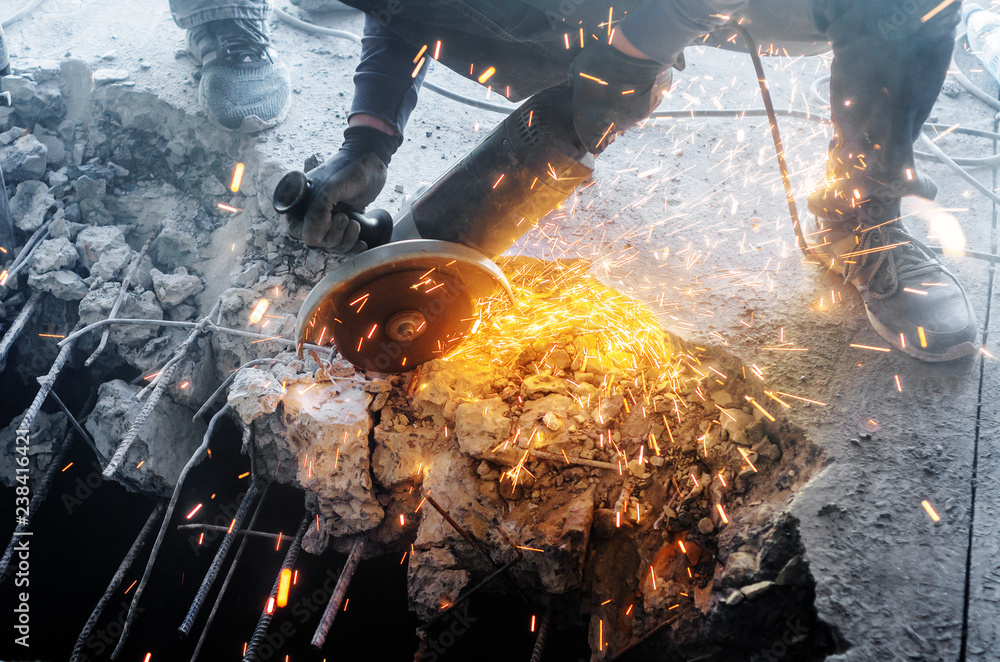 Foto Stock Male worker saws a disk grinding saw armature into a ... Foto Stock Male worker saws a disk grinding saw armature into a ...