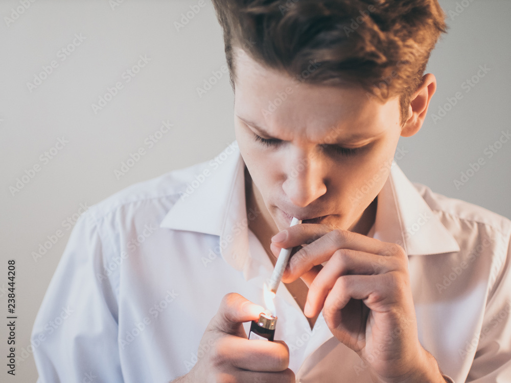 Young handsome guy smoking a cigarette, studio shooting. Stock Photo ...