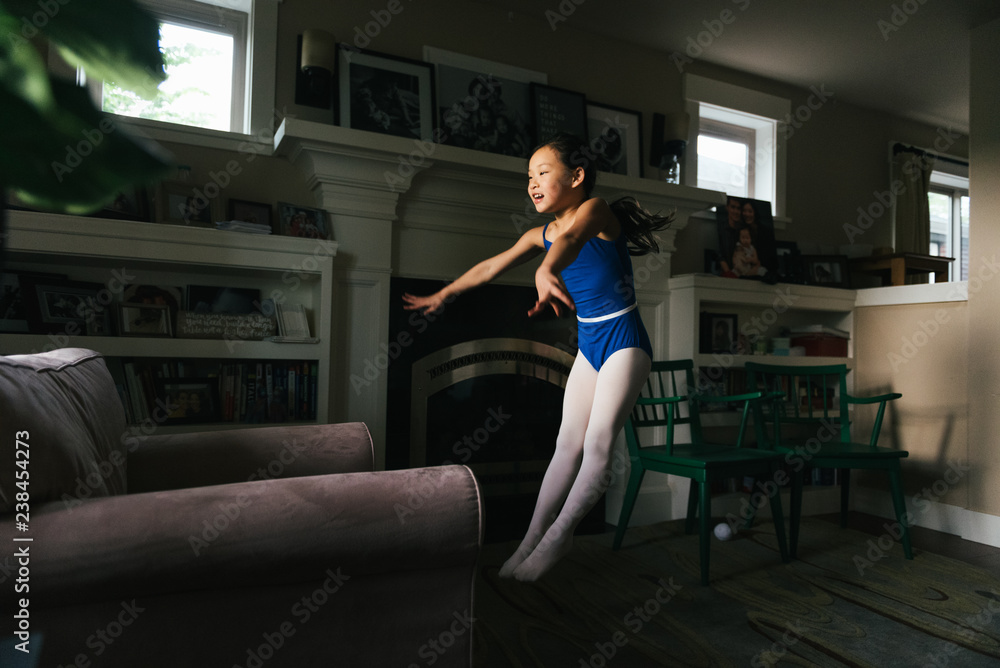 Young girl practicing gymnastics at home Stock Photo | Adobe Stock