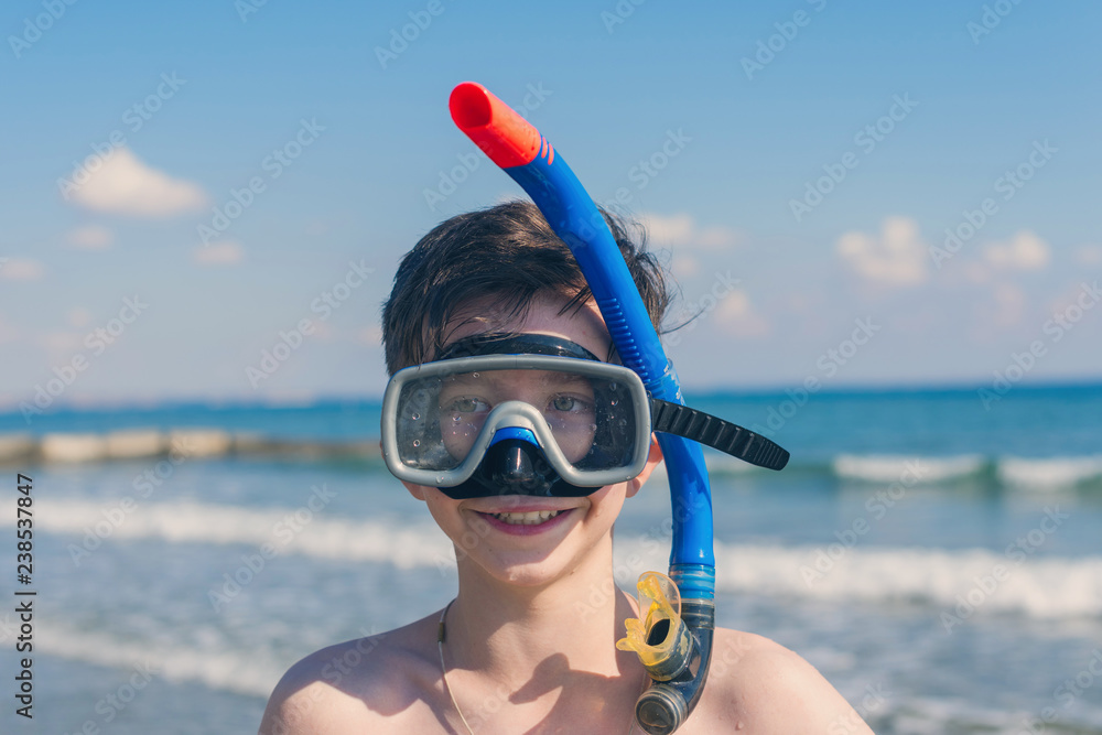Happy and smiling face of boy in the snorkeling mask and tube on the ...