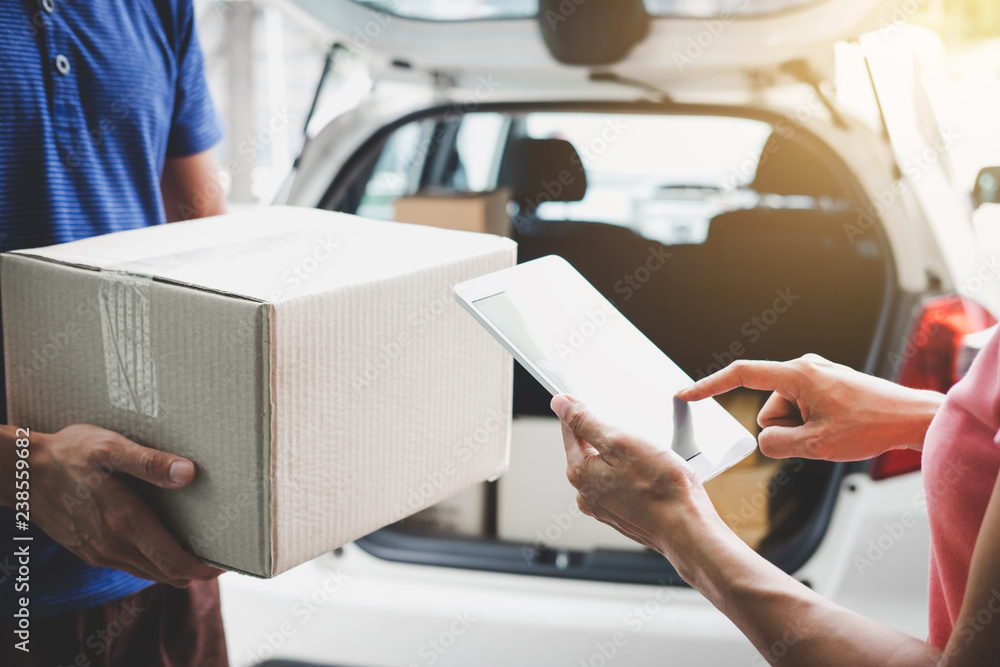 Woman customer appending signature in digital tablet and receiving a ...