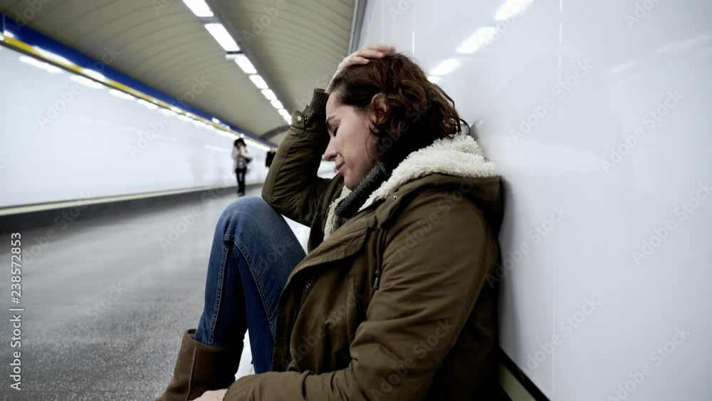 Hopeless and exhausted woman suffering depression and anxiety in subway ...