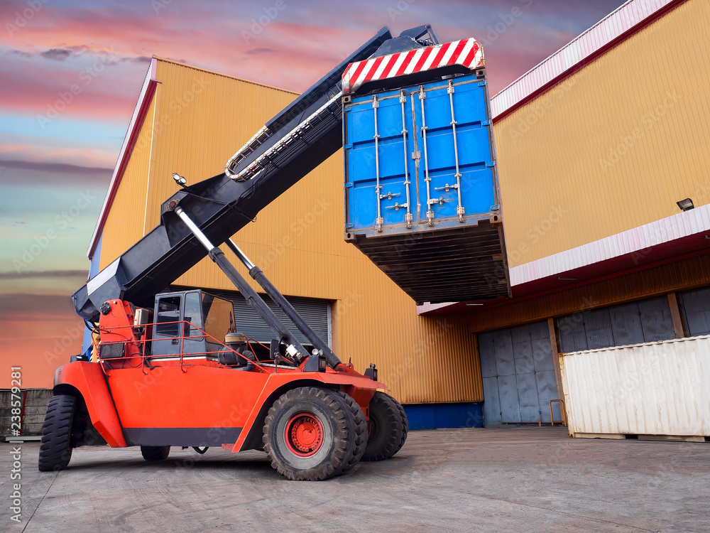 The reach stacker is lifting 20' container to storage area after ...
