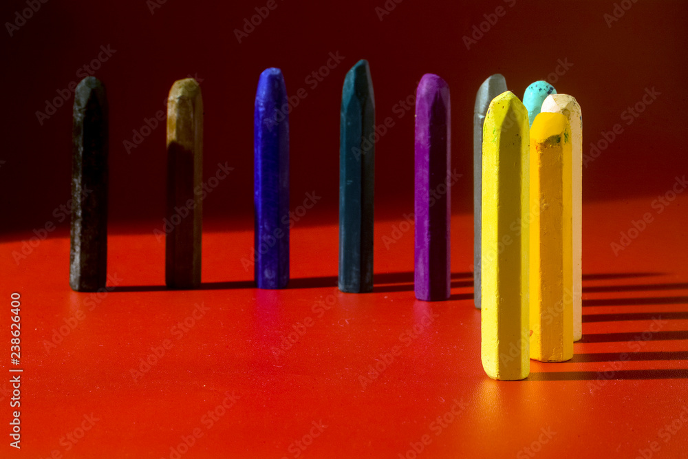 colorful crayons are set up in a line and cause shadows to line up ...