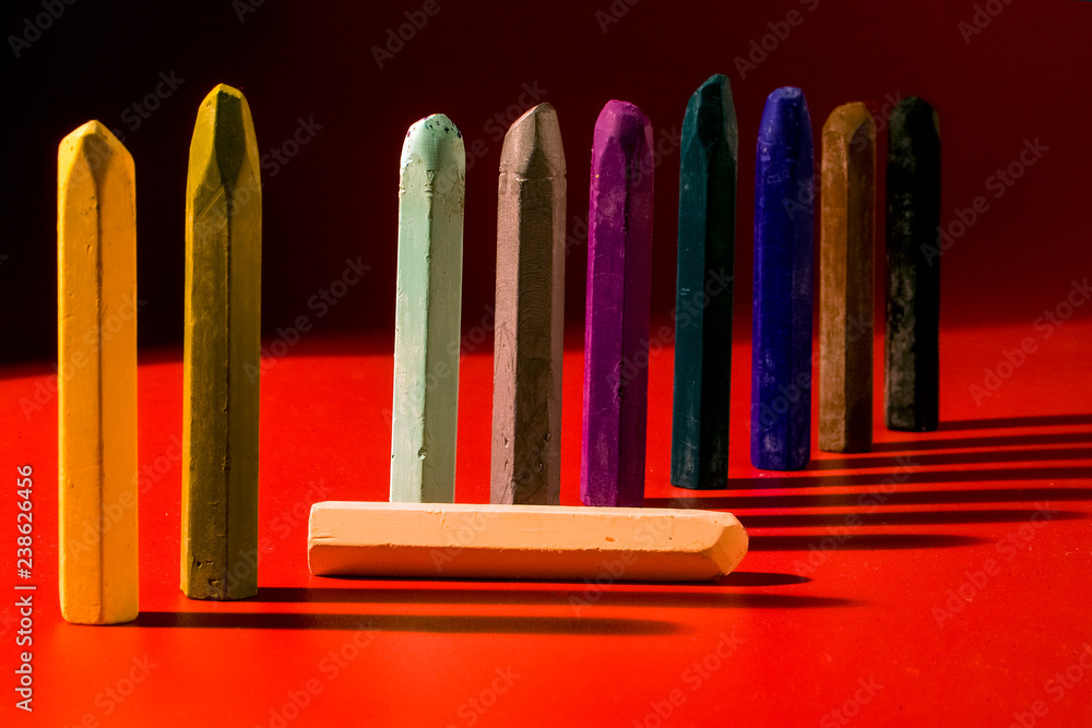 colorful crayons are set up in a line and cause shadows to line up ...
