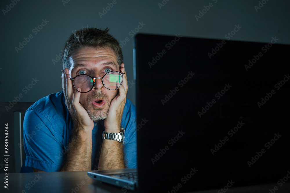 weird shocked and surprised geek man in nerd glasses working on laptop ...