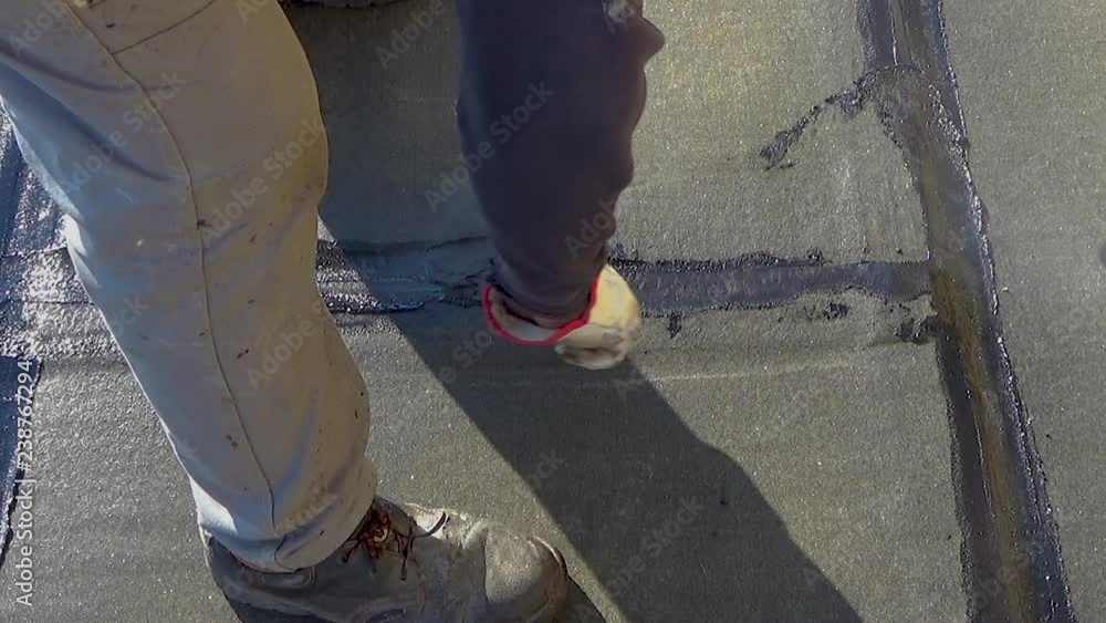 Worker performs sealing overlapping bitumen sheets on the flat roof of ...