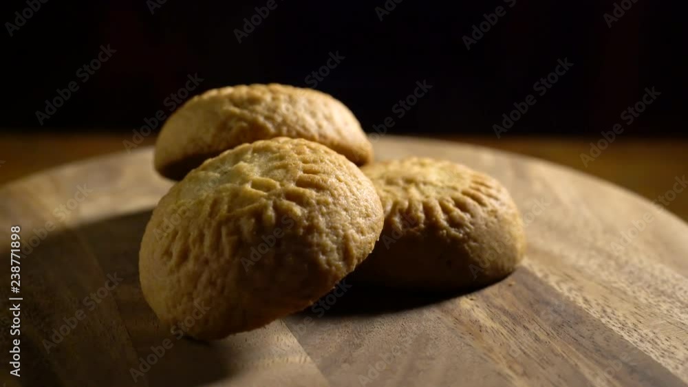 Three maamoul, arabic cookies rotating slowly in pretty light with ...