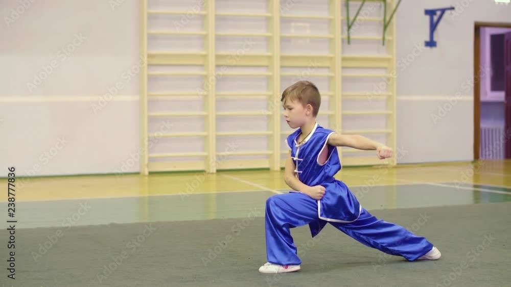 Young caucasian boy in national Chinese dress is practicing Kung Fu ...