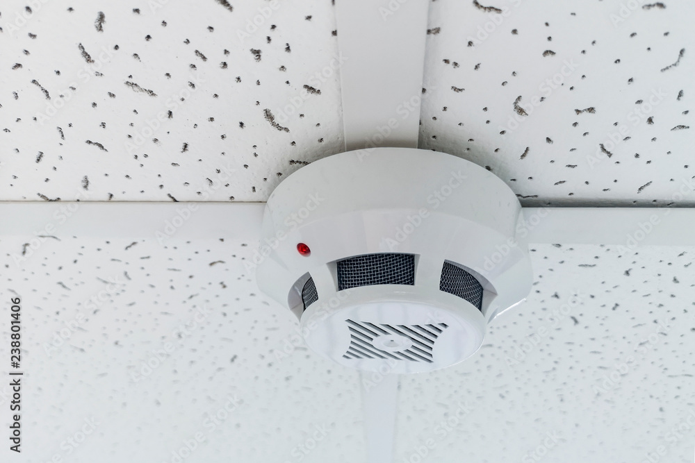 Modern smoke sensor hanging on ceiling. Temperature gage circular wall ...