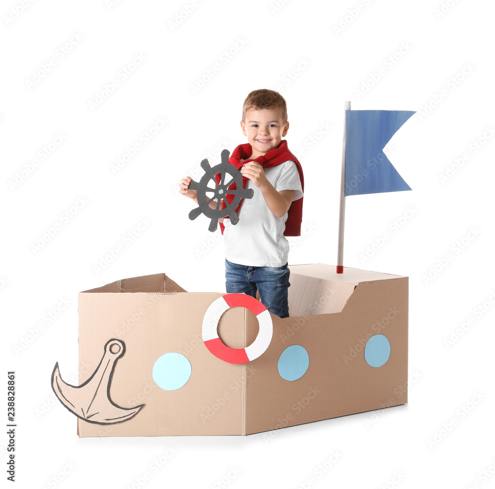 Cute little boy playing with cardboard ship on white background Stock ...