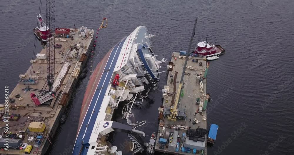 Vidéo Stock Backwards flying wide aerial pan out shot of a capsized ...