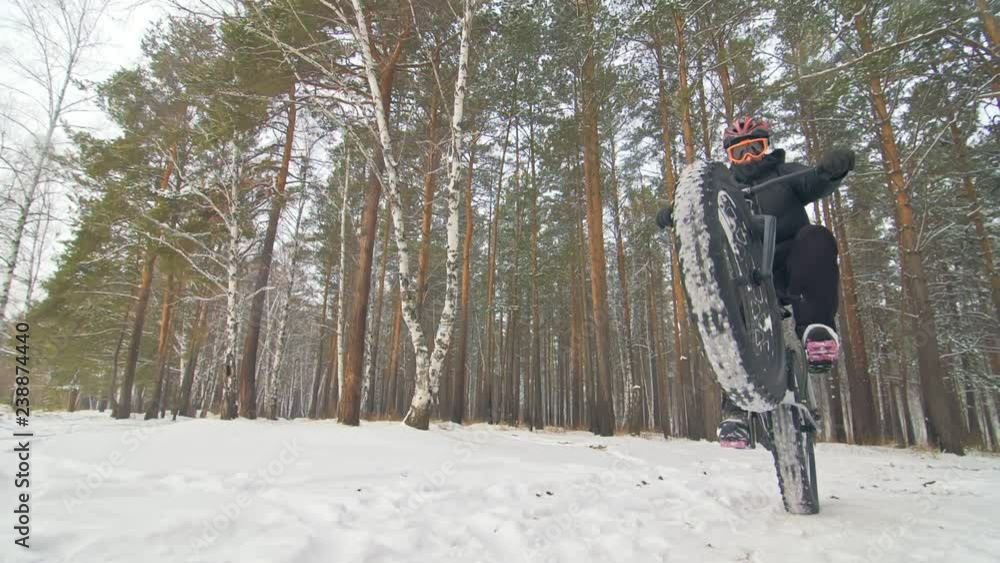 Professional extreme sportsman biker riding fat bike in outdoors ...
