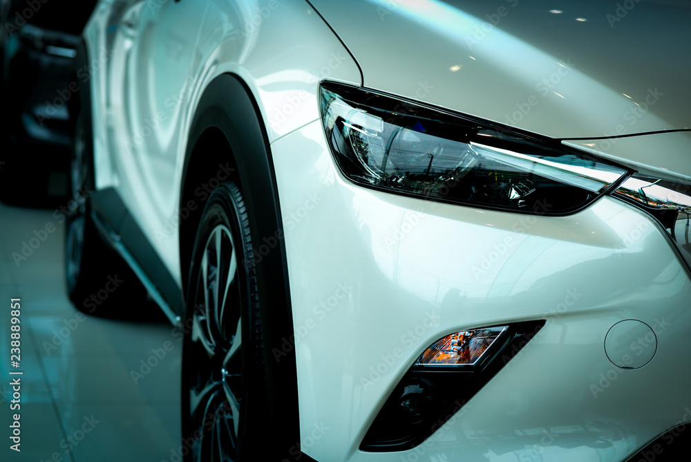 New luxury white car parked in modern showroom. Car dealership office ...