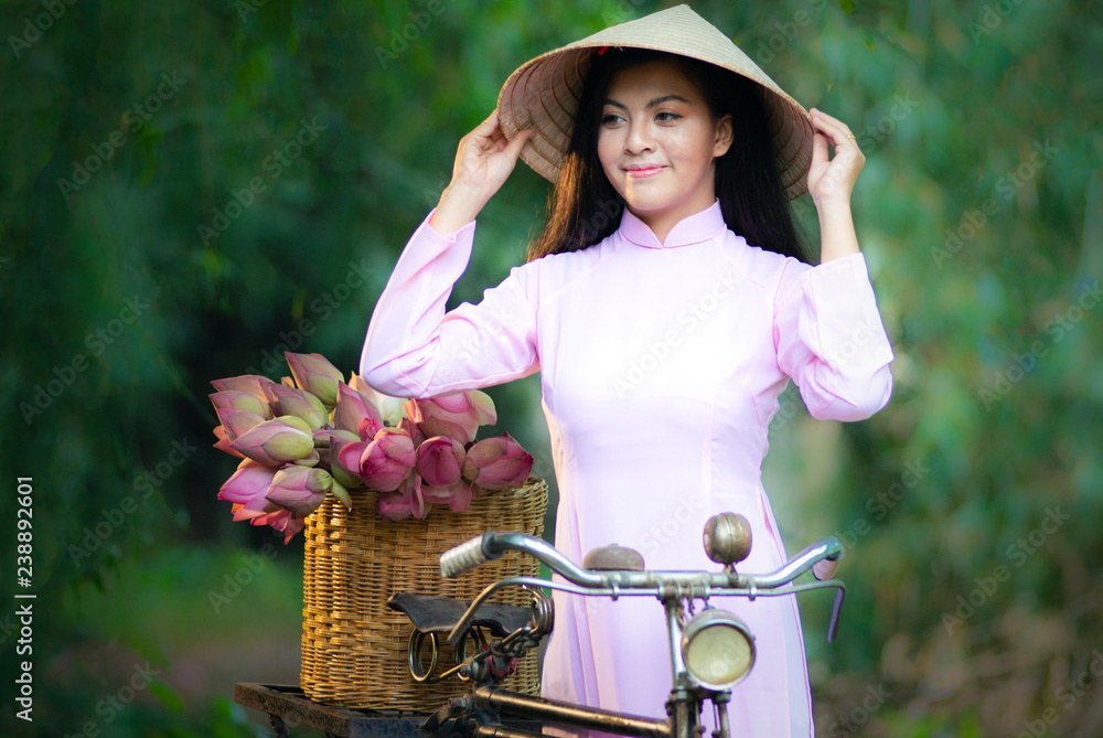 Asian Cute Girl In Vietnamese National Costume Of Vietnam With The Beautiful Of Lotus Flower