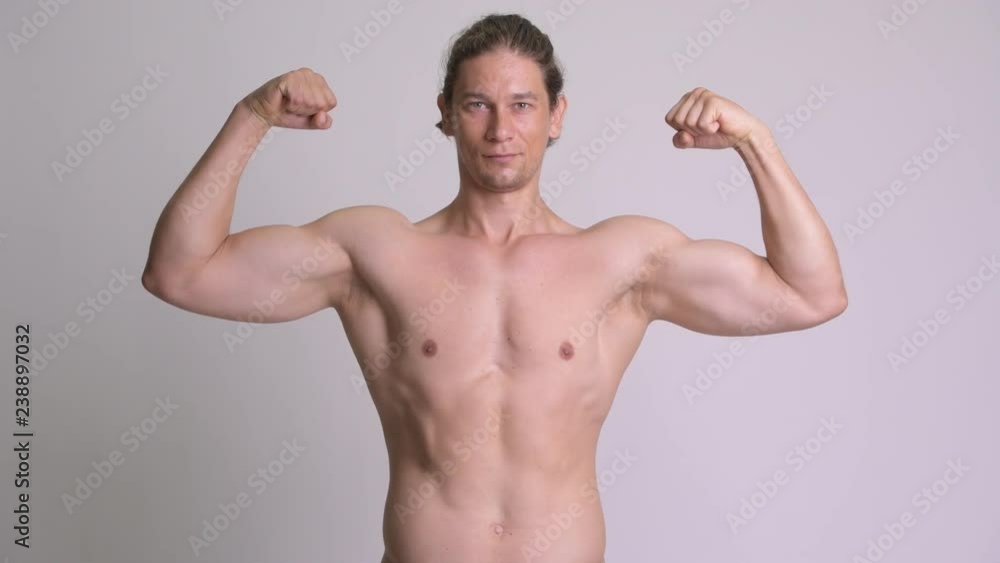 Handsome muscular man flexing biceps shirtless against white background ...