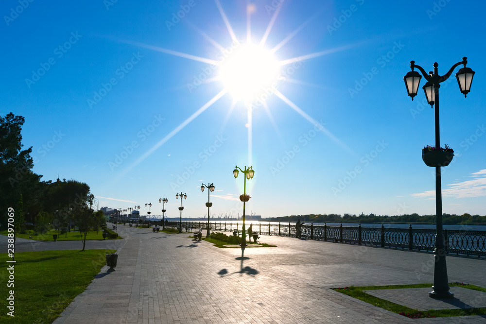 Pedestrian promenade on the banks of the Volga River in bright sunshine ...