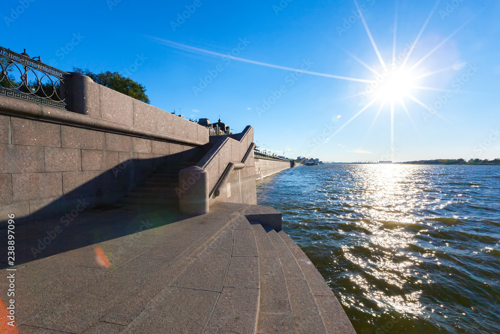 Pedestrian promenade on the banks of the Volga River in bright sunshine ...