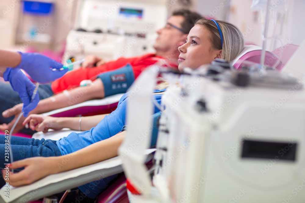 Young woman giving blood in a modern hospital Stock Photo | Adobe Stock
