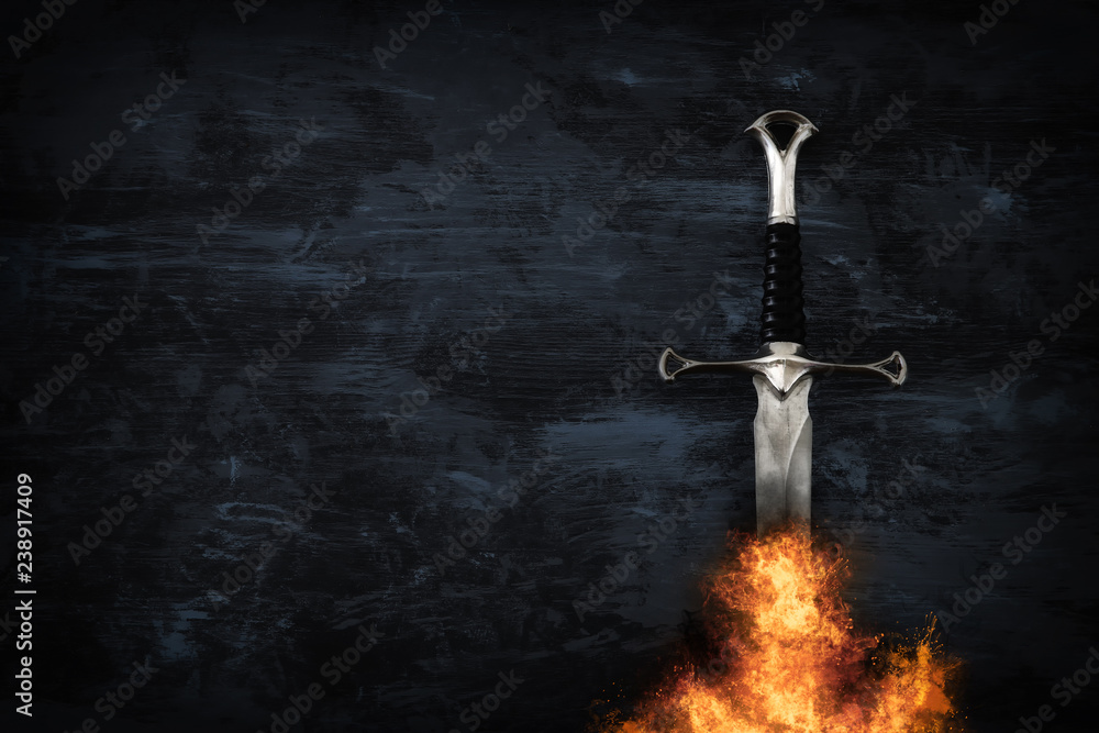 low key image of silver sword in the flames of fire. fantasy medieval ...