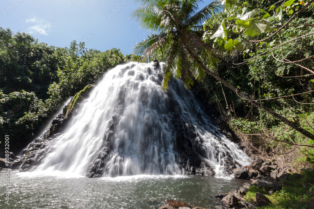 Kepirohi Waterfall in a jungle with palm trees around, near Nan Madol ...