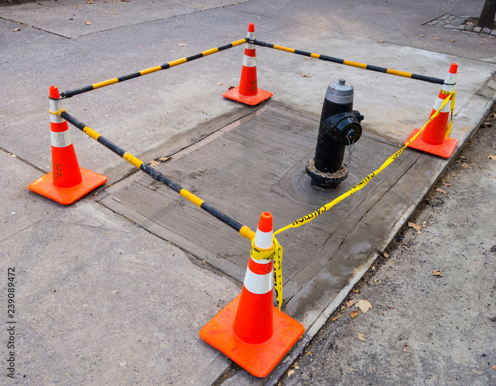 blocked off freshly paved cement walkway / fire hydrant with red orange ...