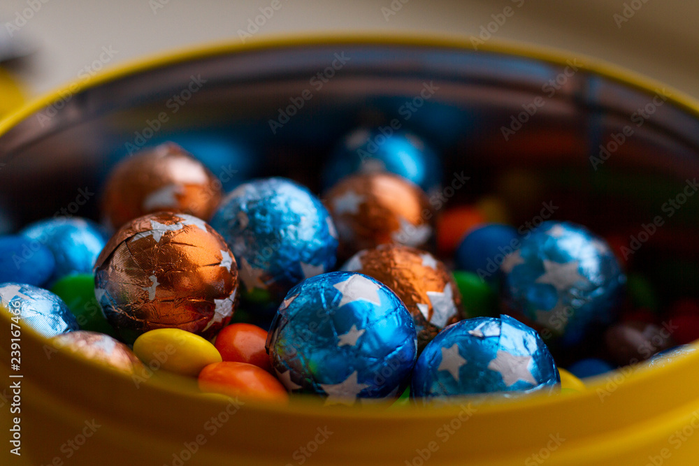 Candies, dragee in the glaze and sweets in a multi-colored foil in a ...