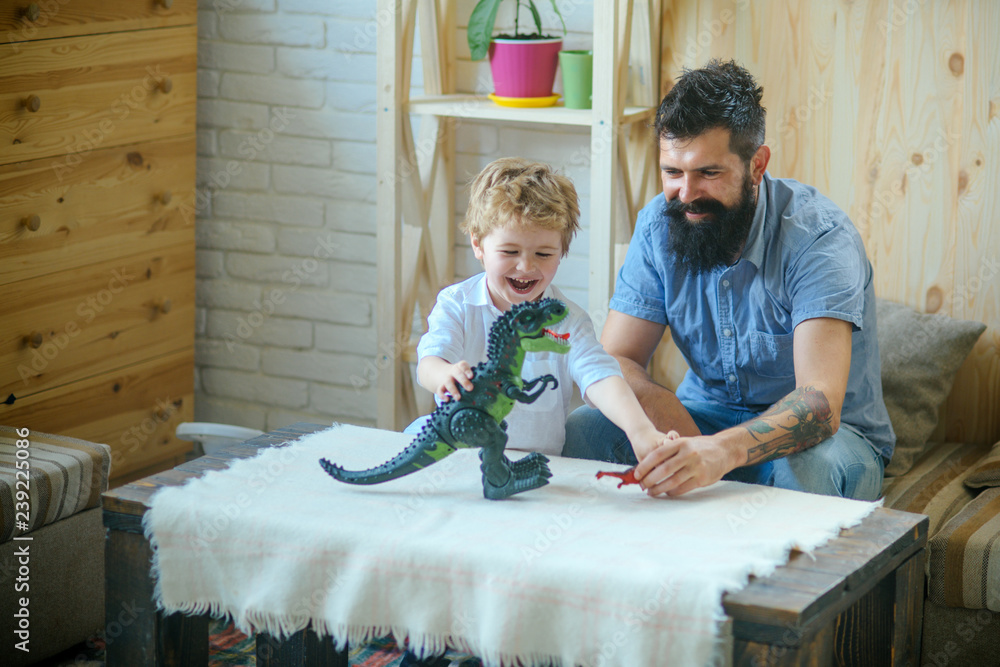 Adorable little child plays with his bearded father with plastic ...