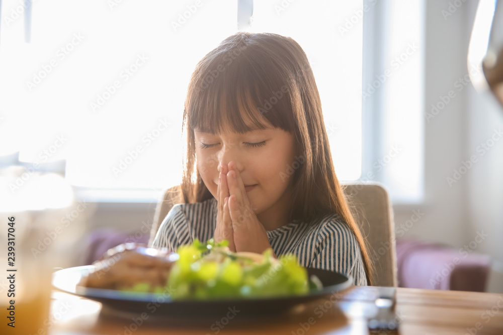Little girl praying before meal at home Stock Photo | Adobe Stock