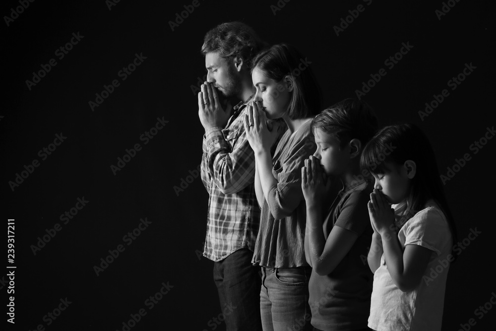 Praying family on dark background Stock Photo | Adobe Stock