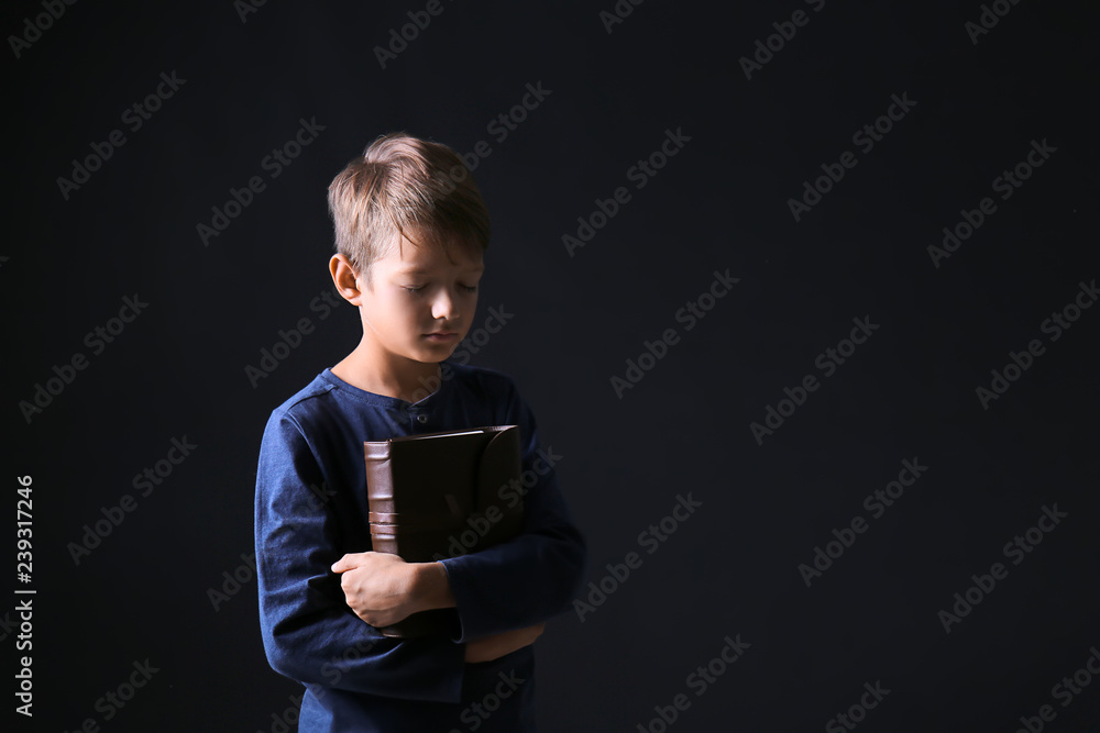 Portrait of praying boy with Bible on dark background Stock Photo ...