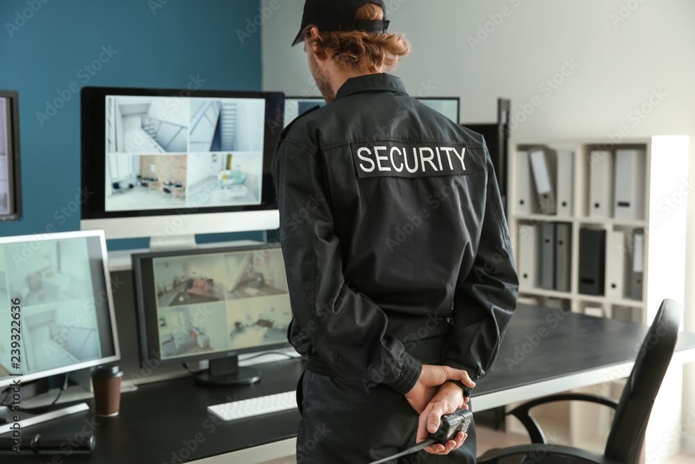 Security guard monitoring modern CCTV cameras in surveillance room ...
