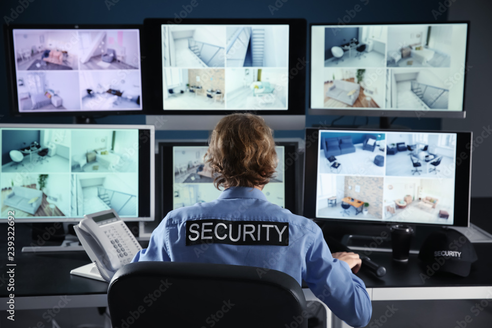 Security guard monitoring modern CCTV cameras in surveillance room ...