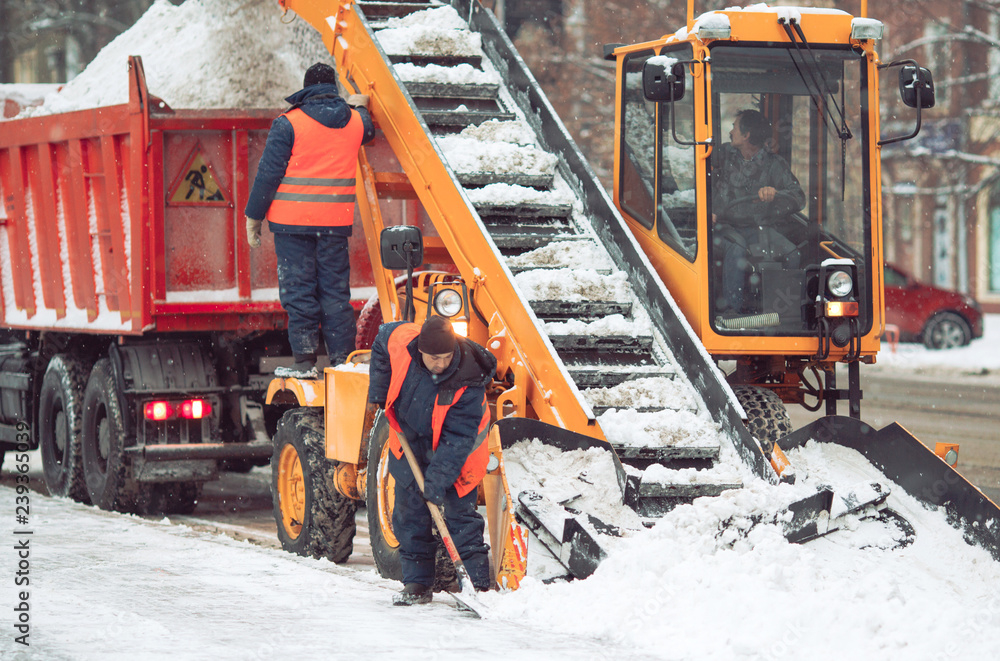 Snow cleaning tractor snow-removal machine loading pile of snow on a ...