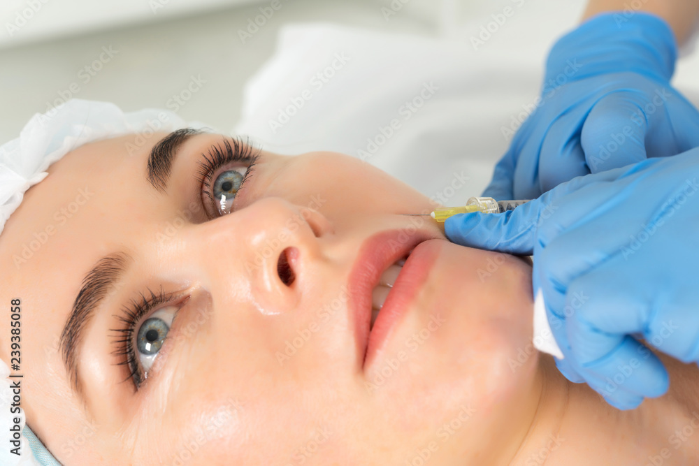 The doctor cosmetologist makes the Rejuvenating facial injections ...