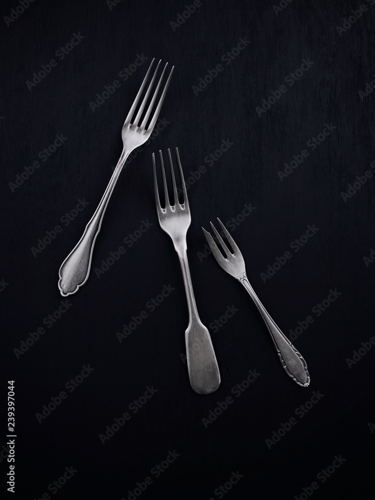 Three forks on black background Stock Photo | Adobe Stock