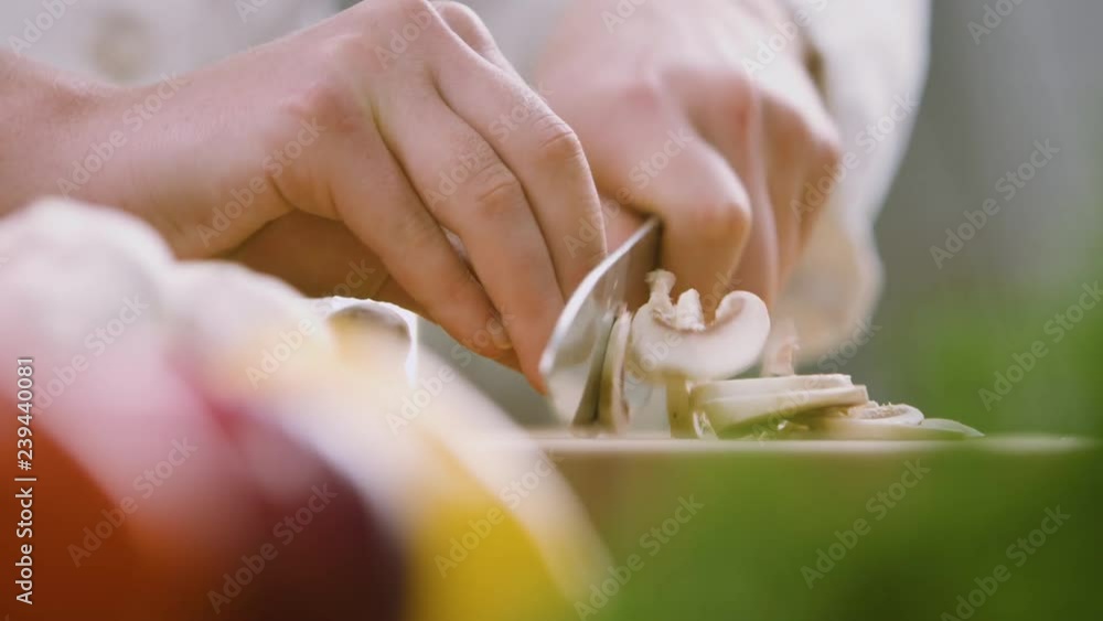 Close up of chef hands and sharp knife, demonstrating mushroom cutting ...