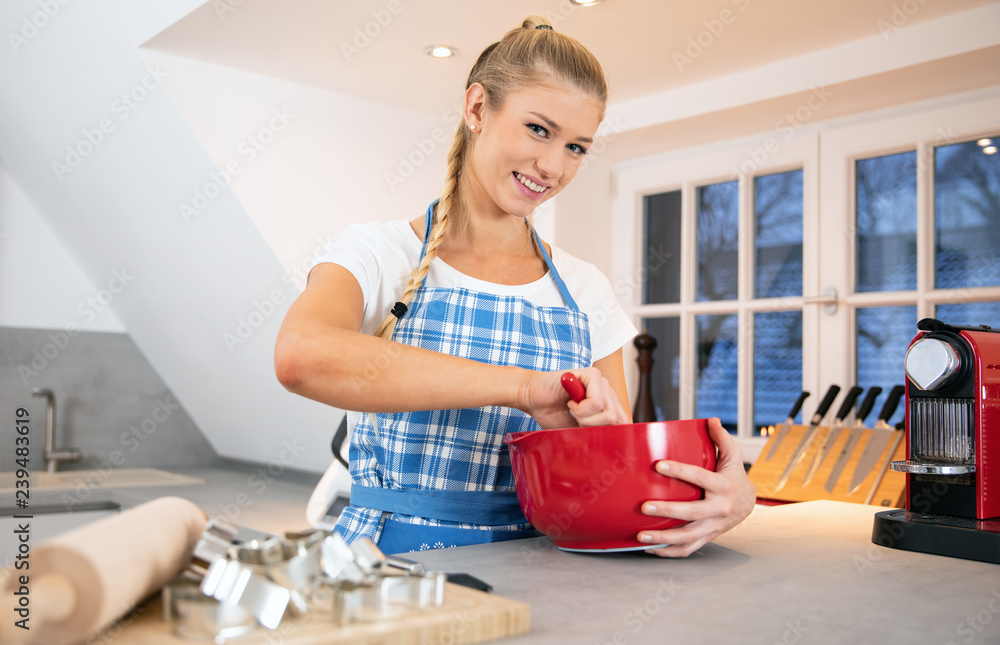 junge blonde Frau backt in der Küche Pläzchen Keckse für Weihnachten ...