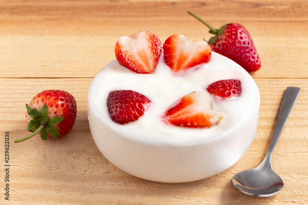 Bowl of yogurt and red fruit strawberry on the wood table. Yogurt made ...