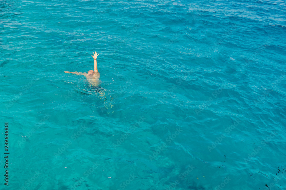 Drowning man in sea asking for help with raised arms. The man is ...